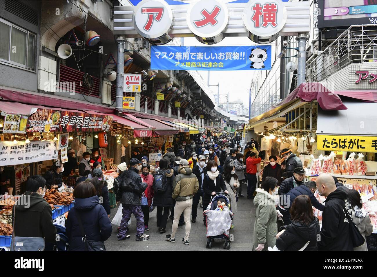 People wearing face masks walk in Tokyo's Ameyoko shopping street on ...