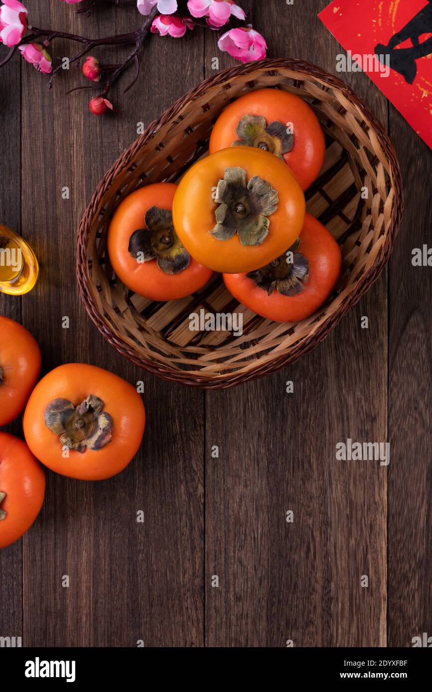 Top view of fresh sweet persimmons kaki with leaves on wooden table ...