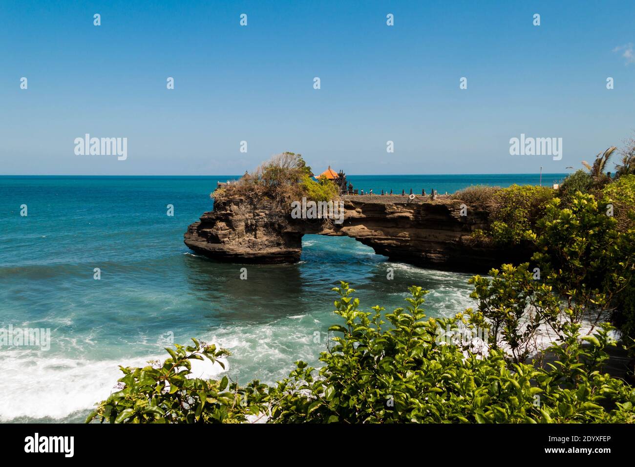 Batu Bolong Temple built on the natural rock formation bridge close to ...