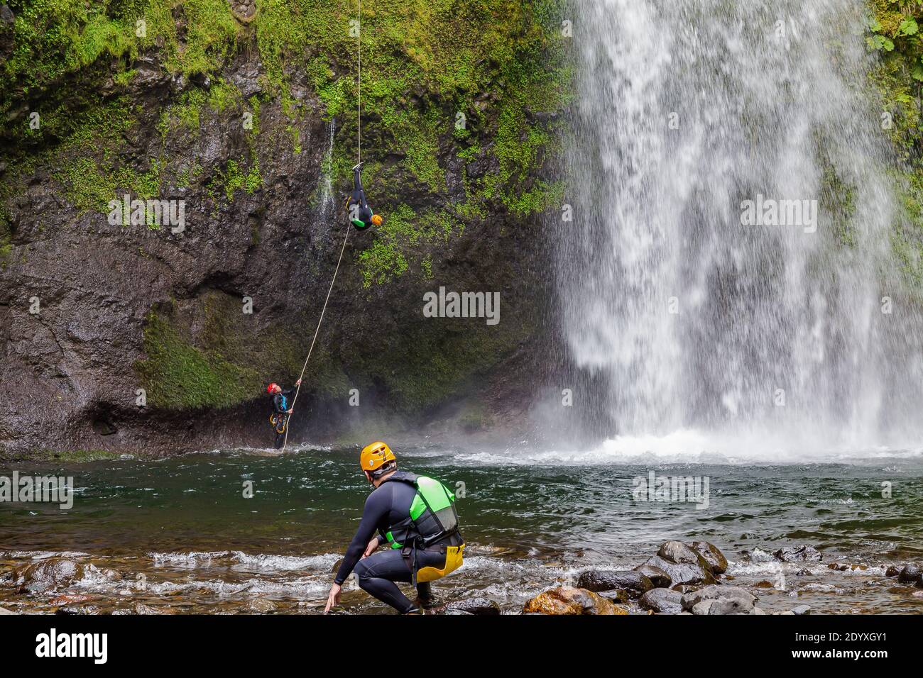 Rock climbers in a helmet hat and safety harness surrounded by ...
