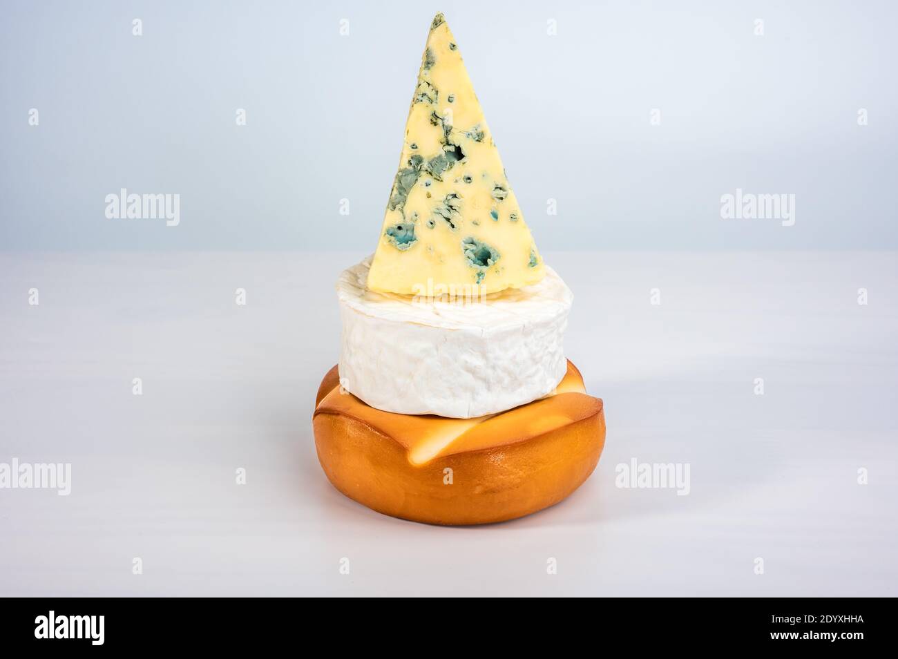 pyramid of cheese. smoked cheese, brie and mouldy cheese are stacked on ...