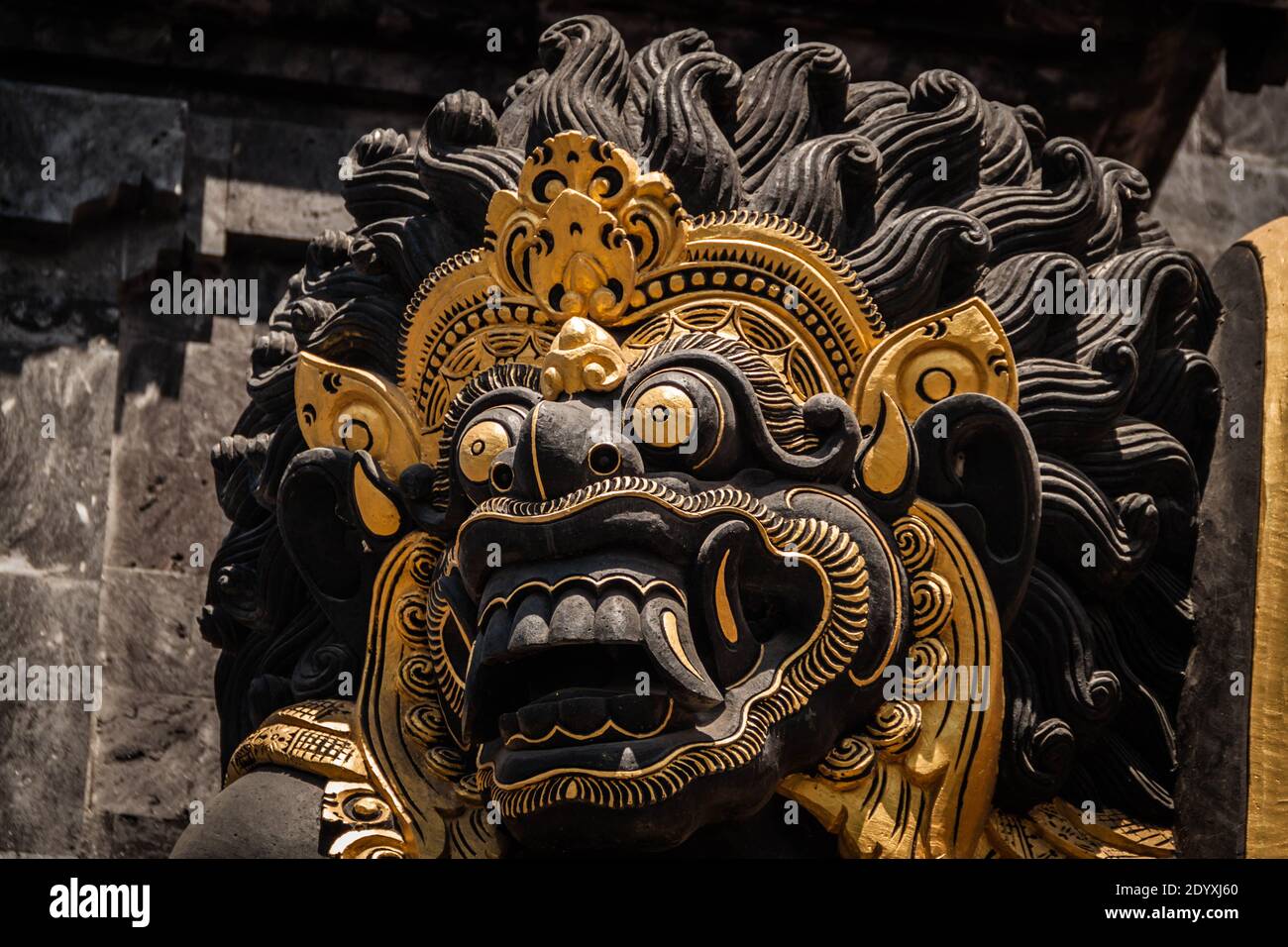 A close up image of the face of a gate guardian (Dvarapala) in Bali ...