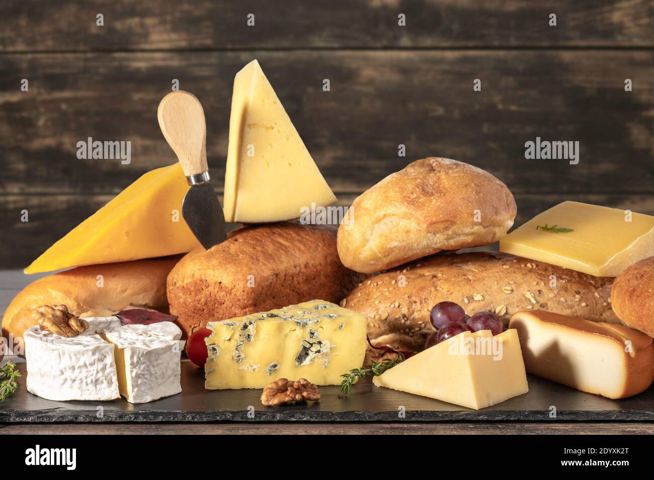 cheese and bread. many types of bread and cheese on wooden rustic ...