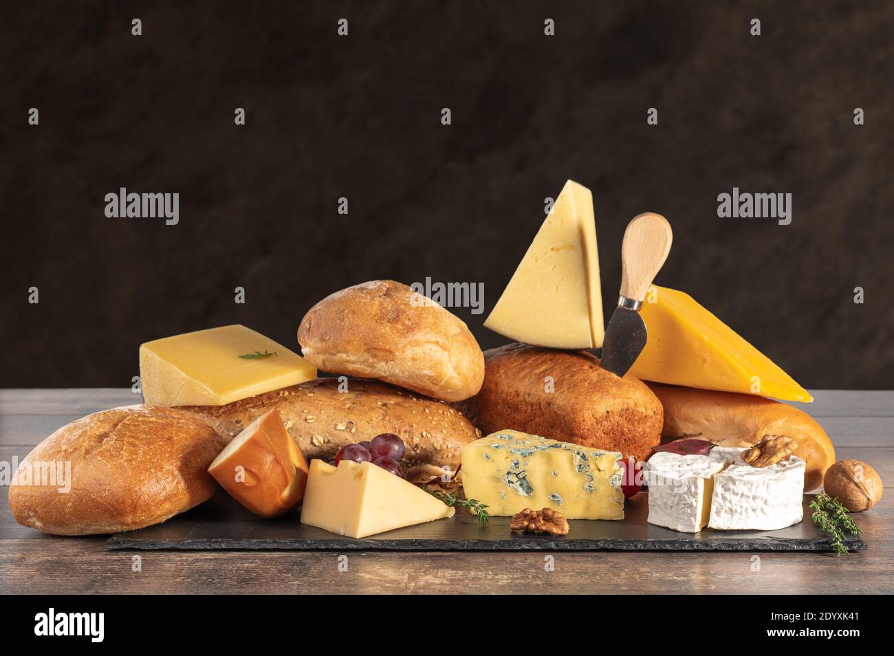 cheese and bread. many types of bread and cheese on brown background ...