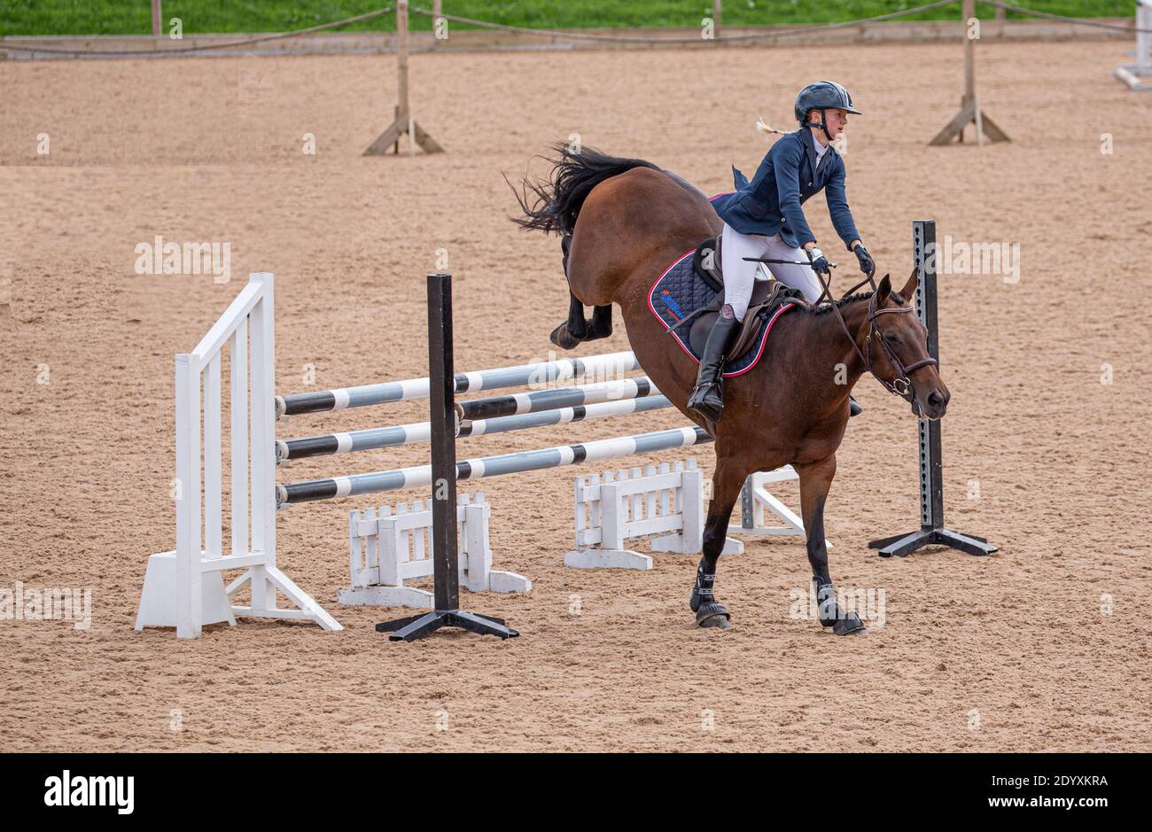 An equestrian rider on their horse jumping over a fence as they take ...