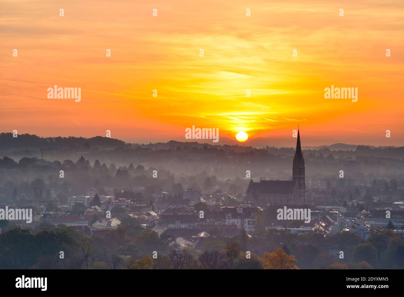 Amazing sunrise over the city of Graz with Church of the Sacred Heart ...