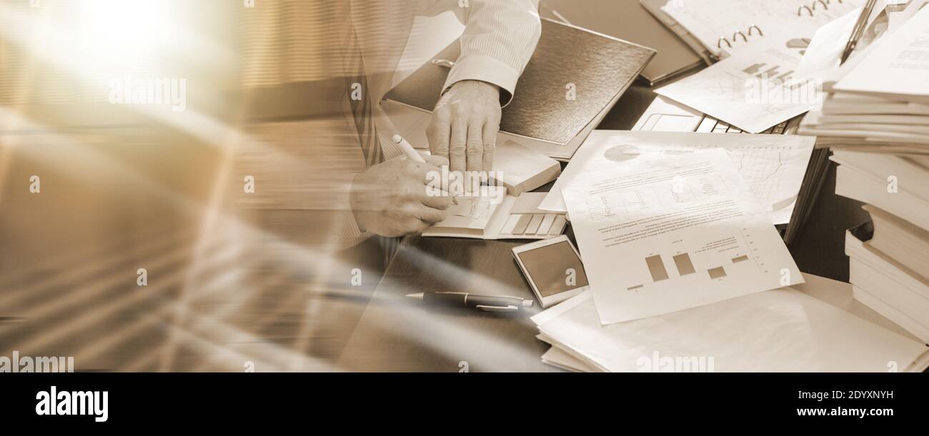 Businessman working at an untidy and cluttered desk; multiple exposure ...