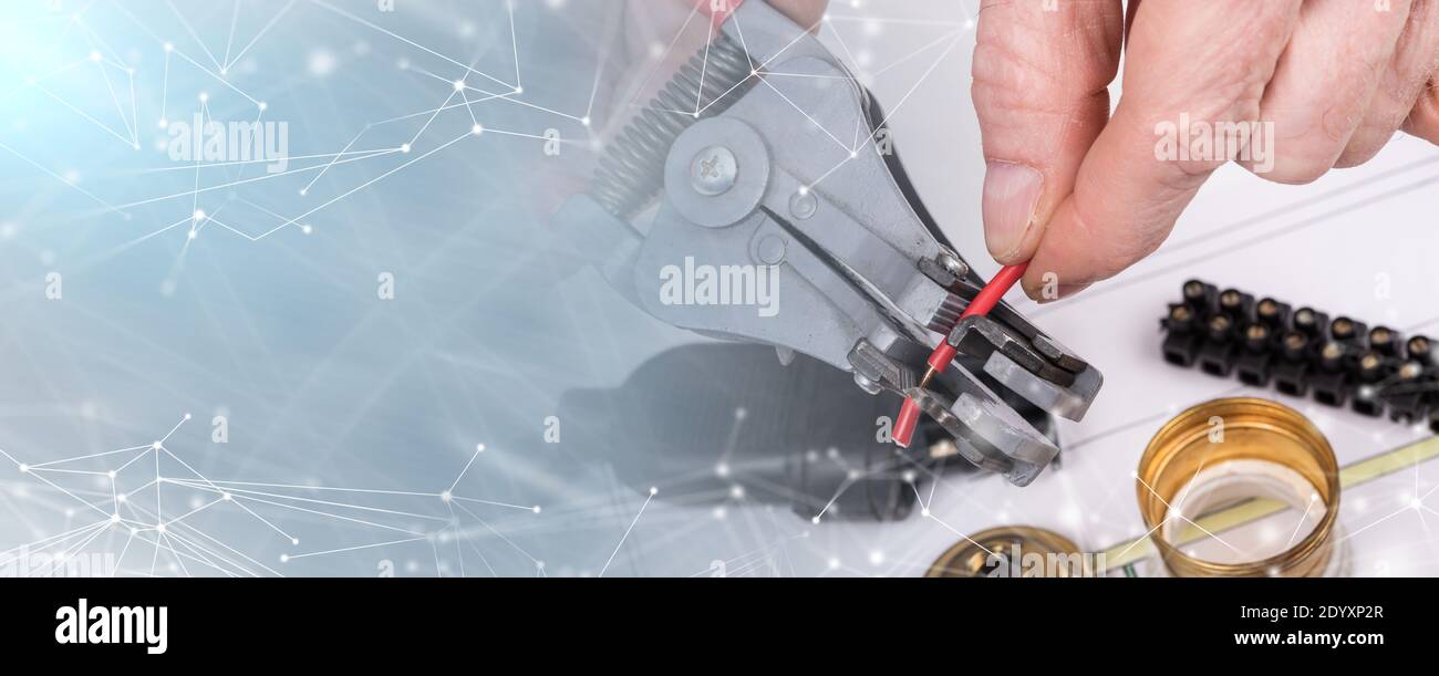 Action to strip a wire with a wire stripper, closeup; panoramic banner ...