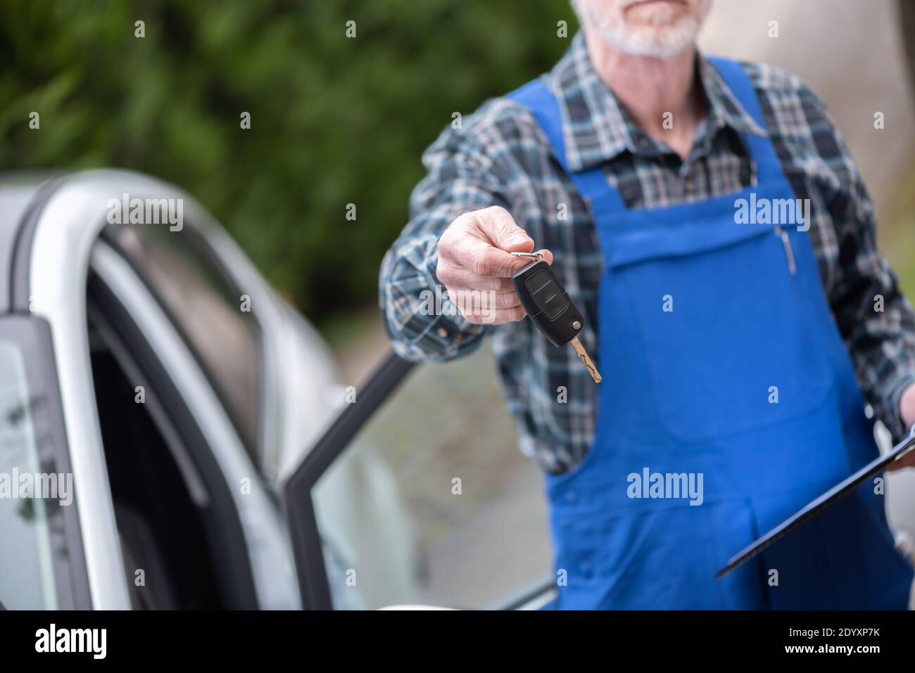 Car mechanic delivering car keys after car engine checking Stock Photo ...