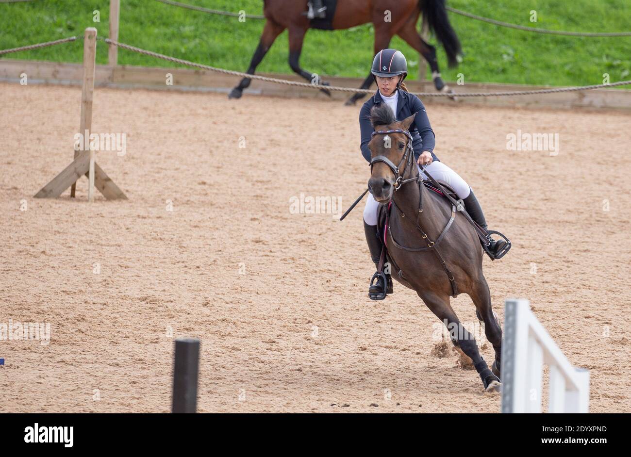 An equestrian rider on their horse jumping over a fence as they take ...