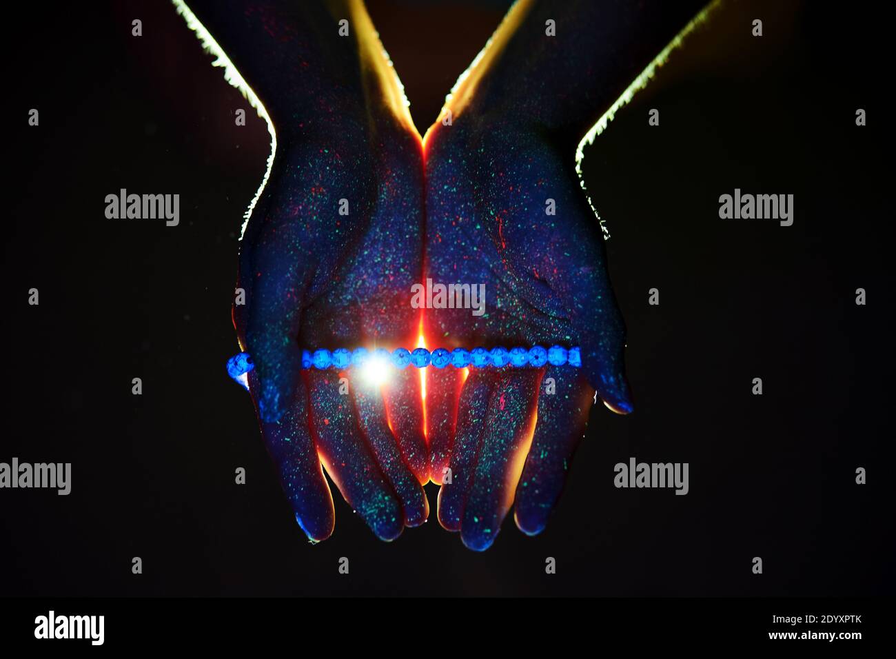 Rosary in hand, prayer. Light through the palms of your hands in ...