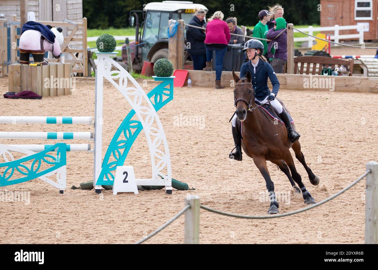 An equestrian rider on their horse jumping over a fence as they take ...
