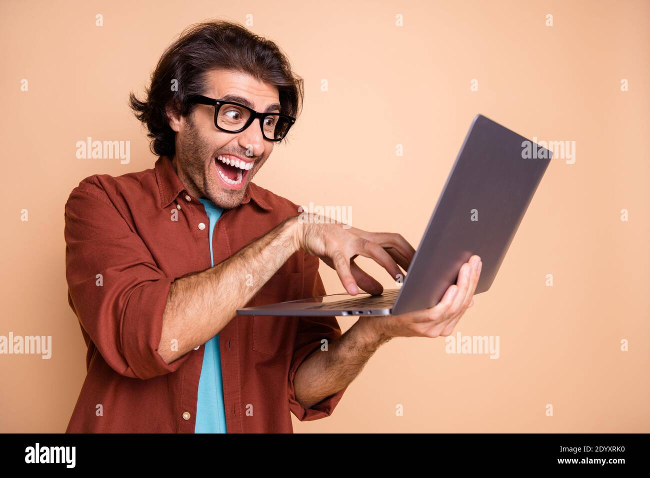 Photo portrait of evil guy laughing typing isolated on pastel beige ...