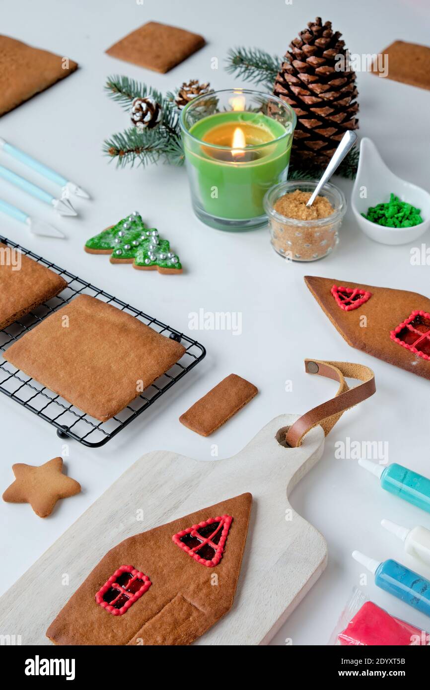 Making of gingerbread house, baked details arranged on white background ...