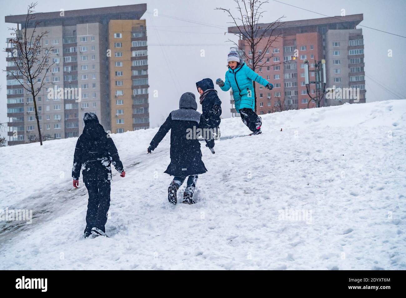 Snowfall in Moscow, Russia. Children sliding down a slope Stock Photo ...