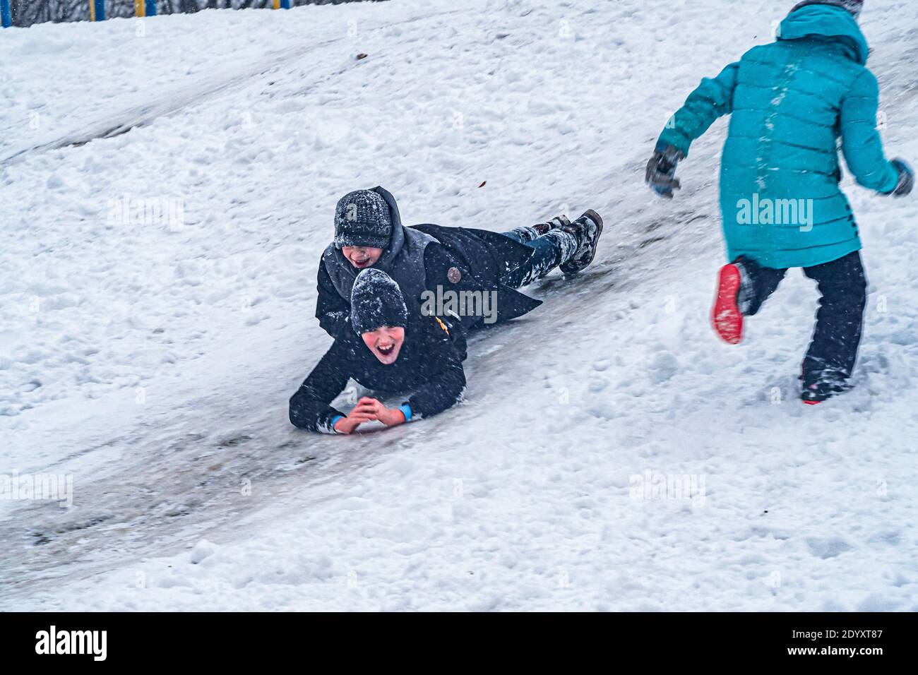 Snowfall in Moscow, Russia. Children sliding down a slope Stock Photo ...
