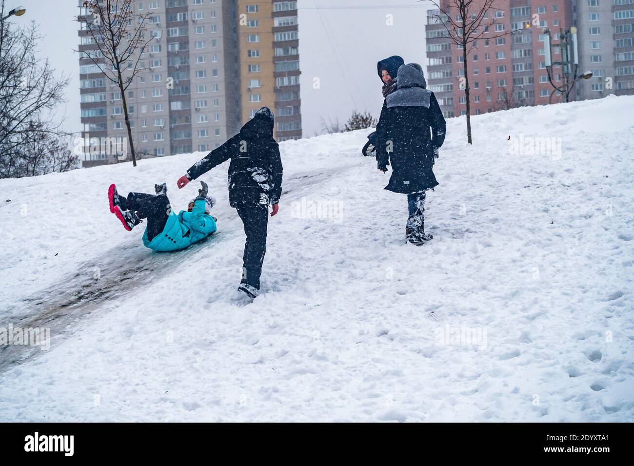 Snowfall in Moscow, Russia. Children sliding down a slope Stock Photo ...