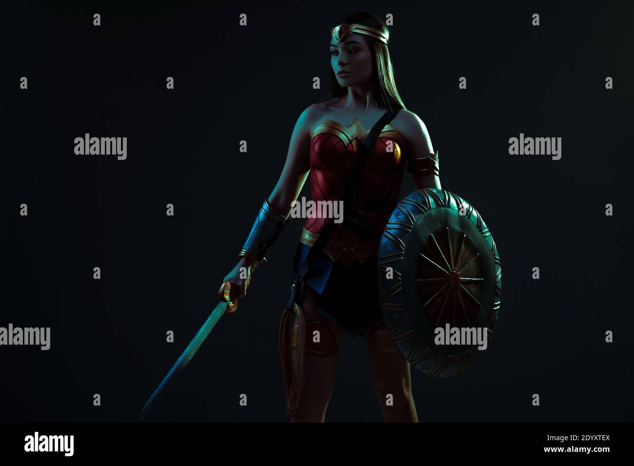 Girl in image of ancient woman warrior stands with sword and shield in ...
