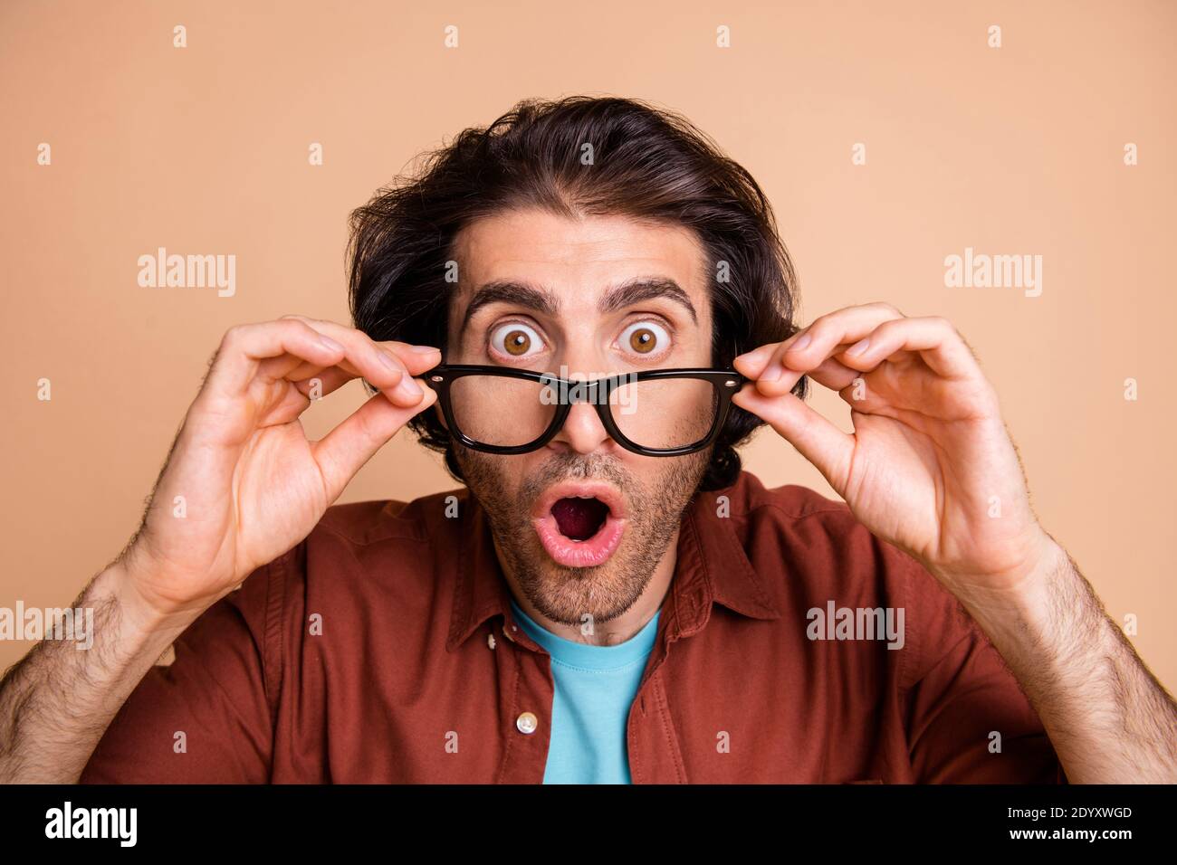Photo of crazy surprised young man fingers hold glasses open mouth wear ...