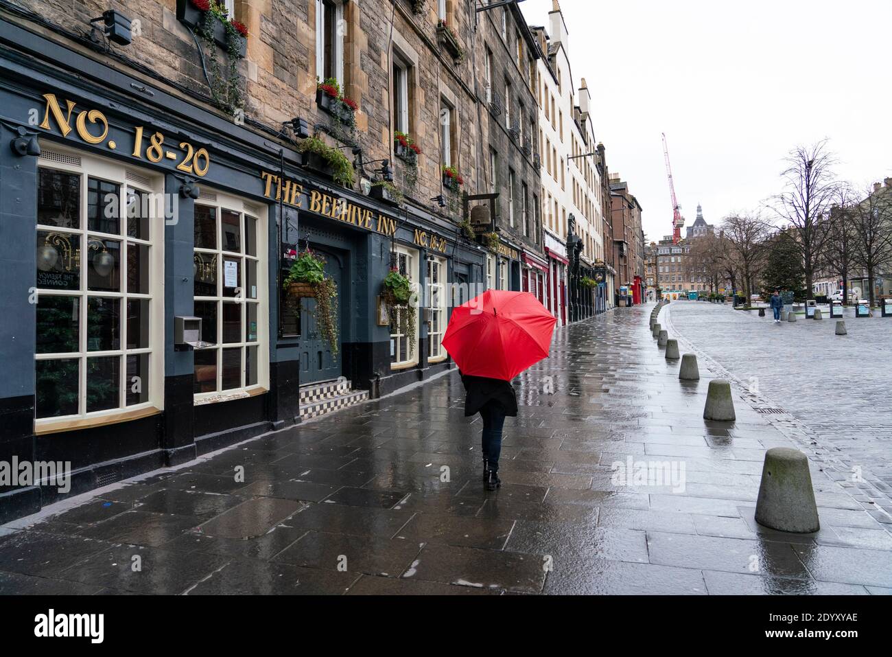 Woman holding red umbrella in rain in The Grassmarket in Old Town of ...