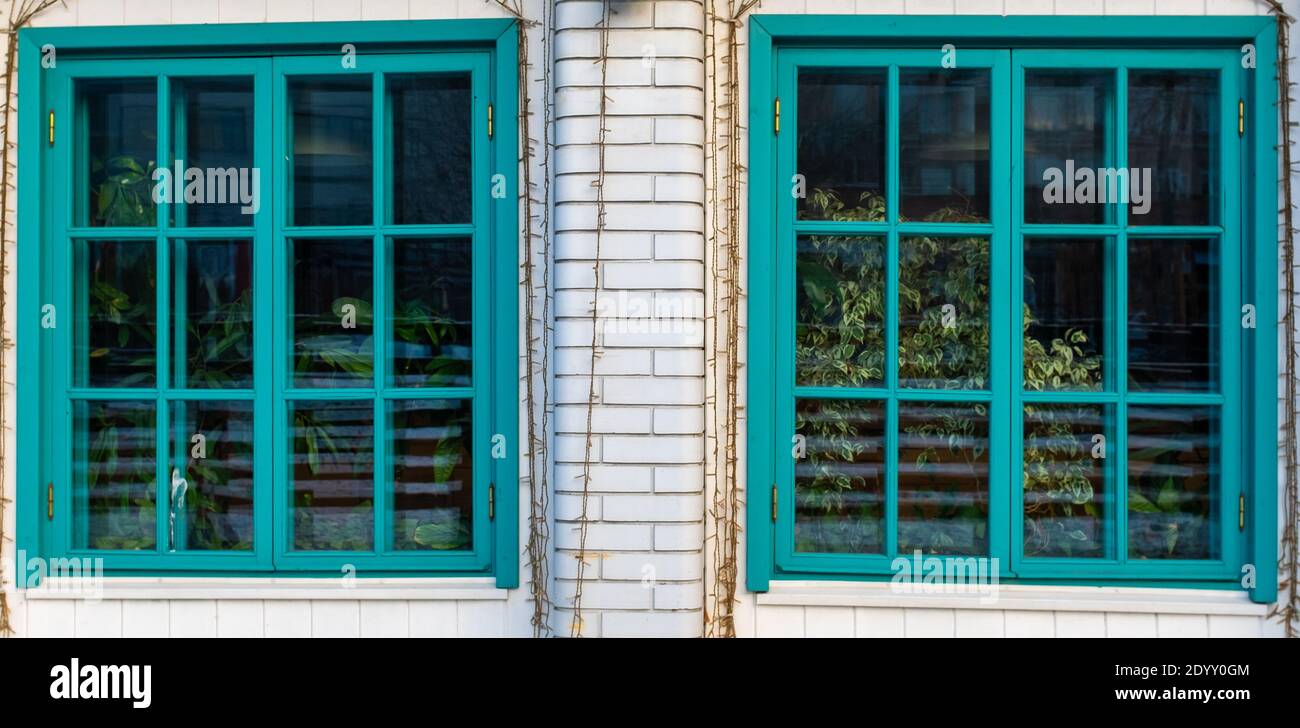 Two large turquoise windows on the veranda of a brick house Stock Photo ...