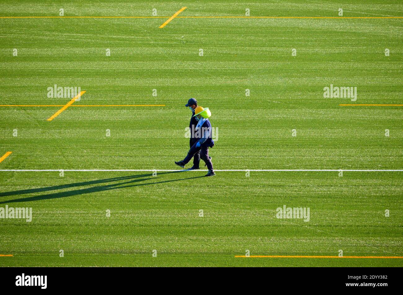 Workers on a public football pitch in Hong Kong Stock Photo - Alamy