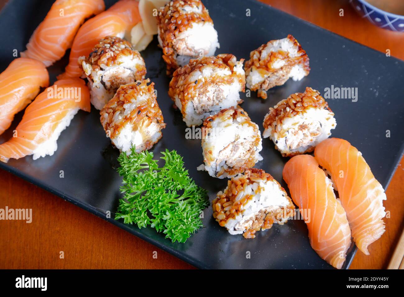 Salmon sushi typical of Japanese cuisine on black plate, natural light ...