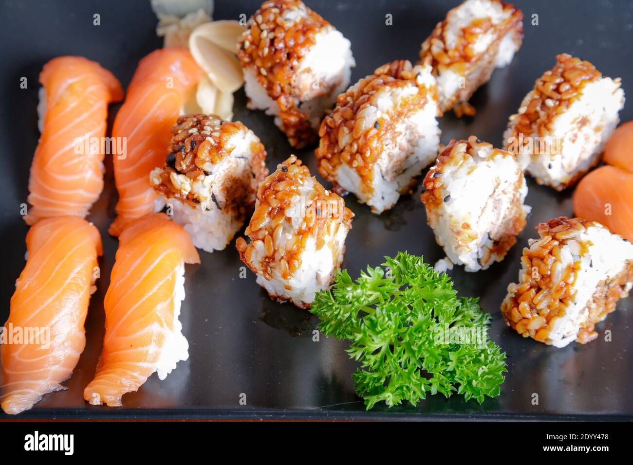 Salmon sushi typical of Japanese cuisine on black plate, natural light ...