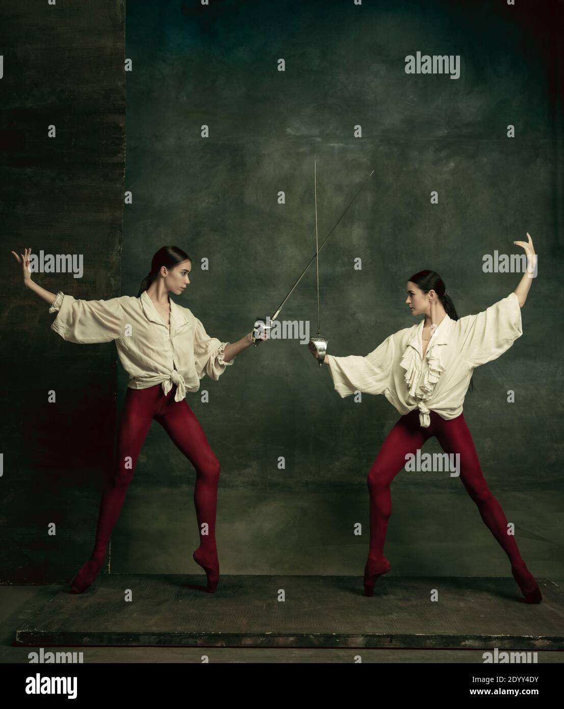 Flexibility. Two young female ballet dancers like duelists with swords ...
