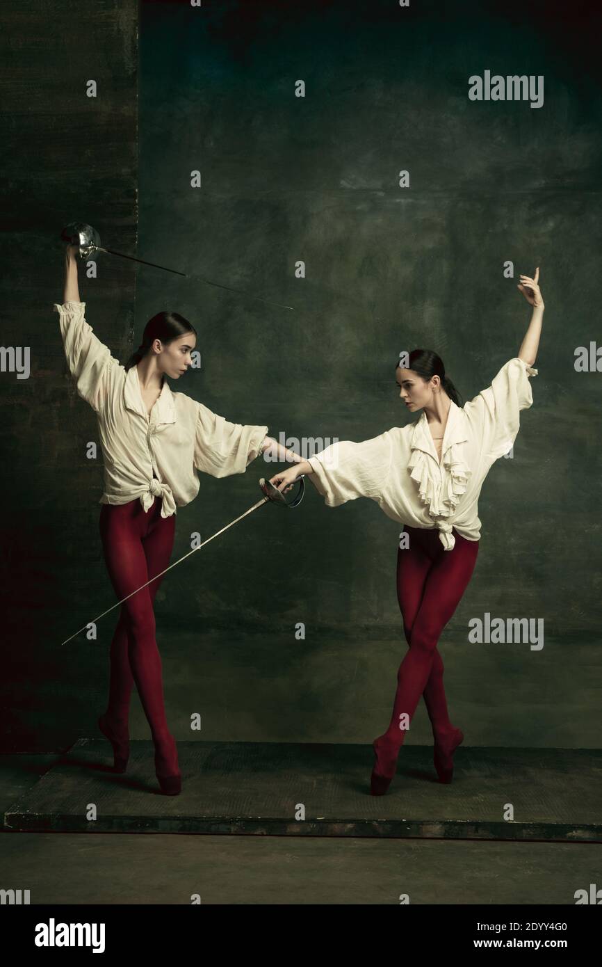 Flexibility. Two young female ballet dancers like duelists with swords ...