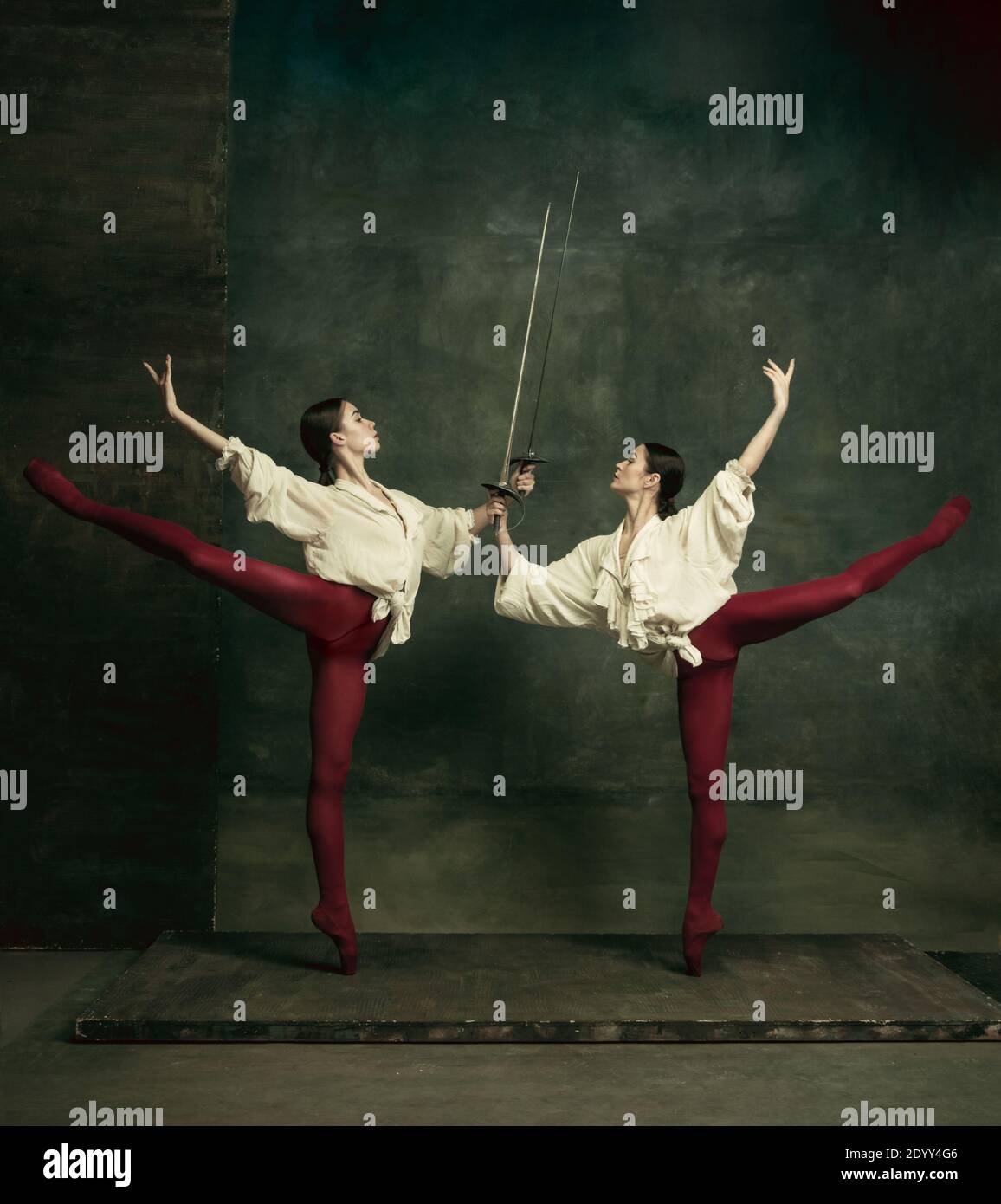 Fight. Two young female ballet dancers like duelists with swords on ...