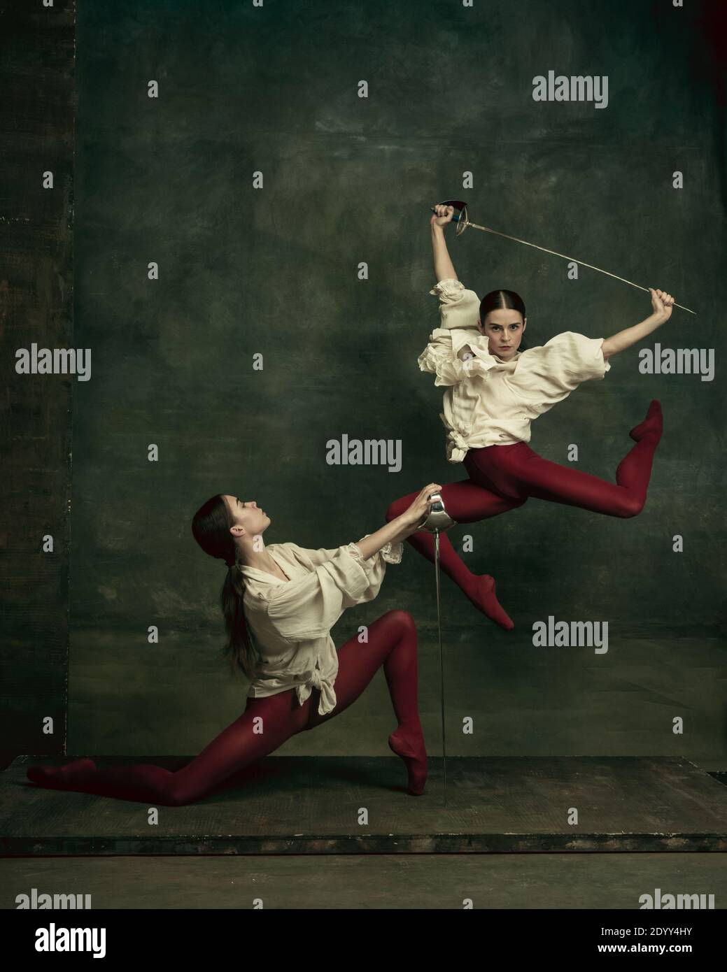 Fight. Two young female ballet dancers like duelists with swords on ...