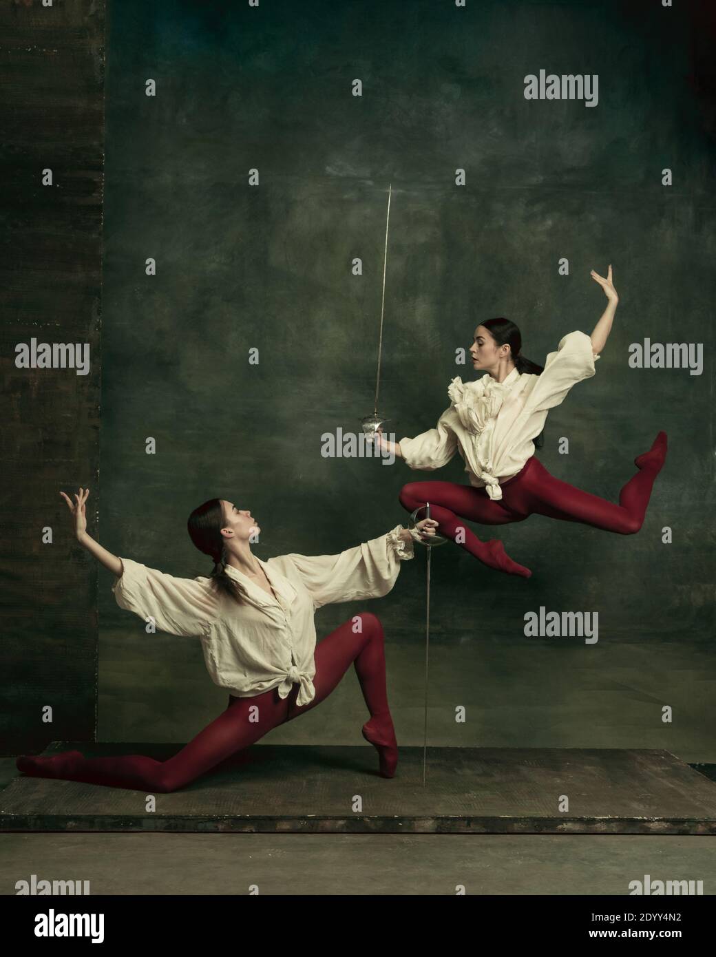 Flying. Two young female ballet dancers like duelists with swords on ...