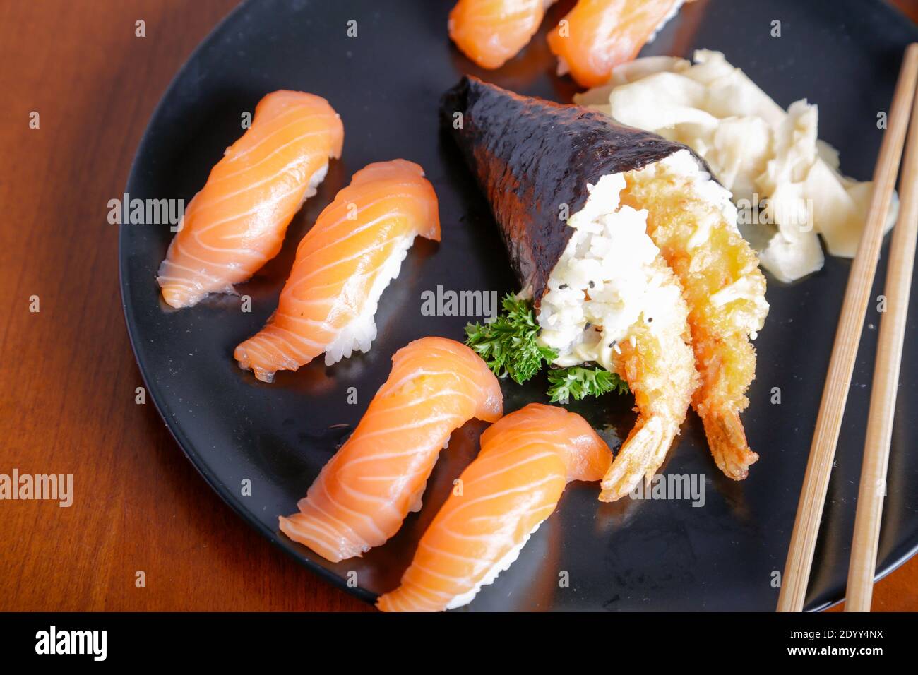 Salmon sushi typical of Japanese cuisine on black plate, natural light ...