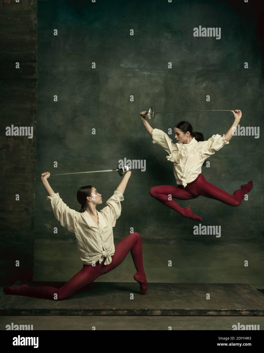 Flying. Two young female ballet dancers like duelists with swords on ...
