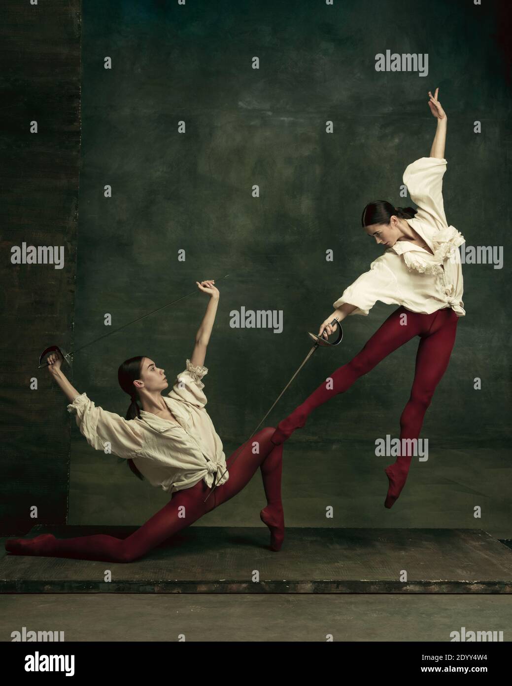 Flying. Two young female ballet dancers like duelists with swords on ...