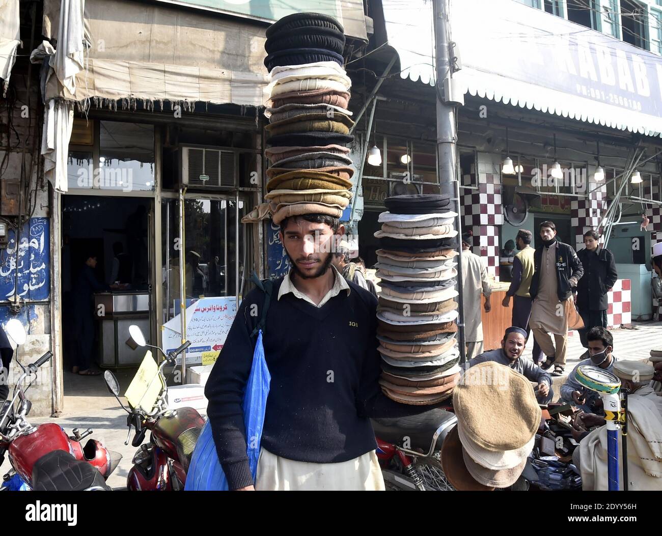 Peshawar. 28th Dec, 2020. A vendor sells traditional caps on a road in ...