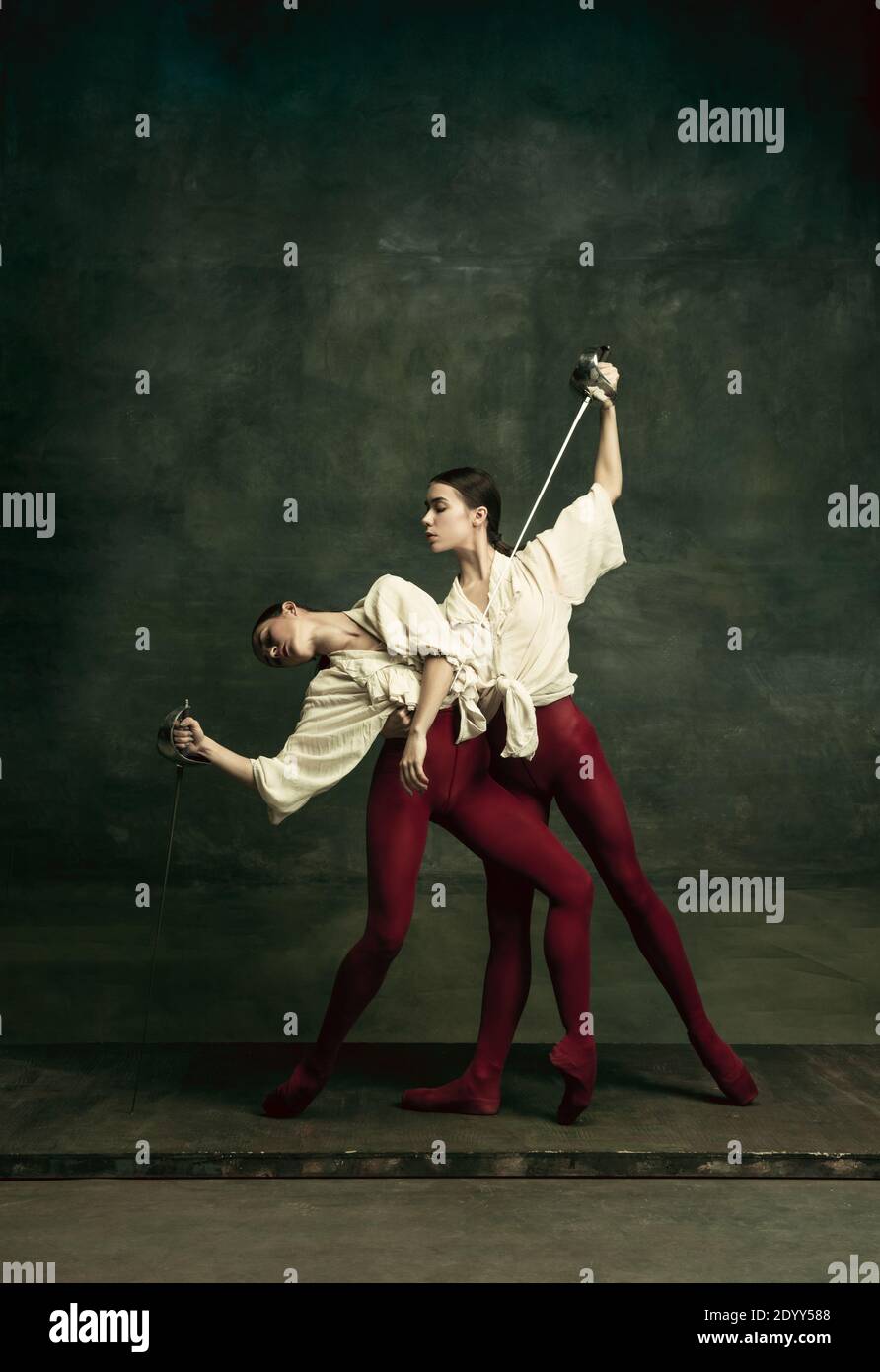 Passioned. Two young female ballet dancers like duelists with swords on ...