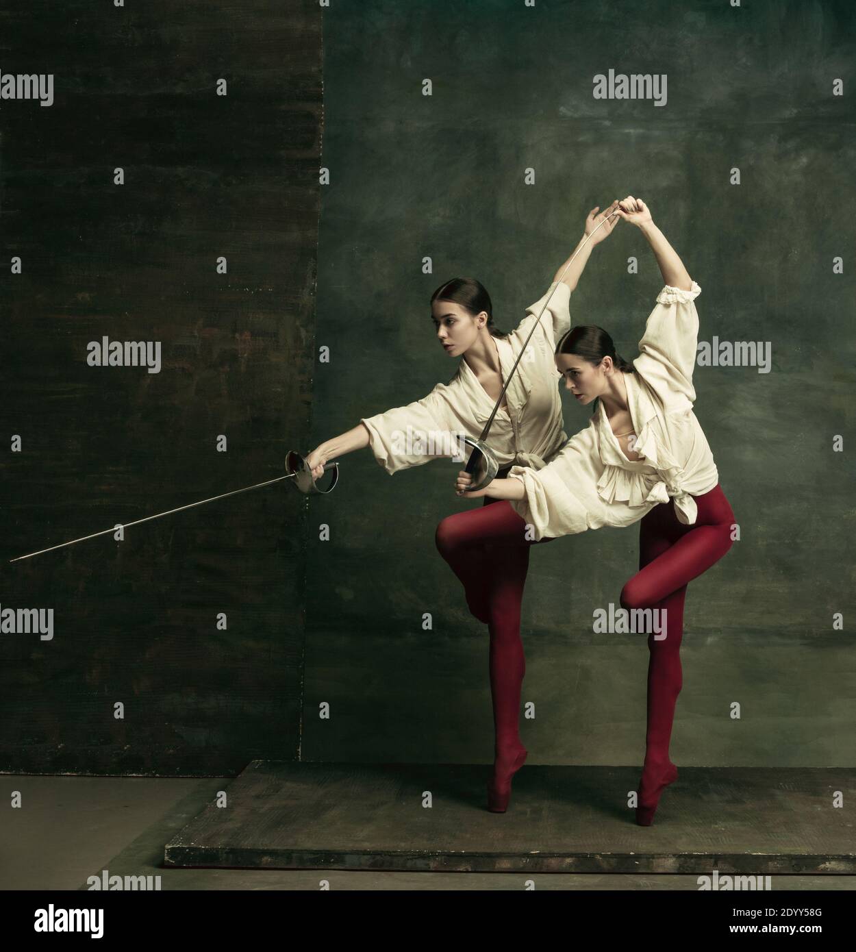 Passioned. Two young female ballet dancers like duelists with swords on ...