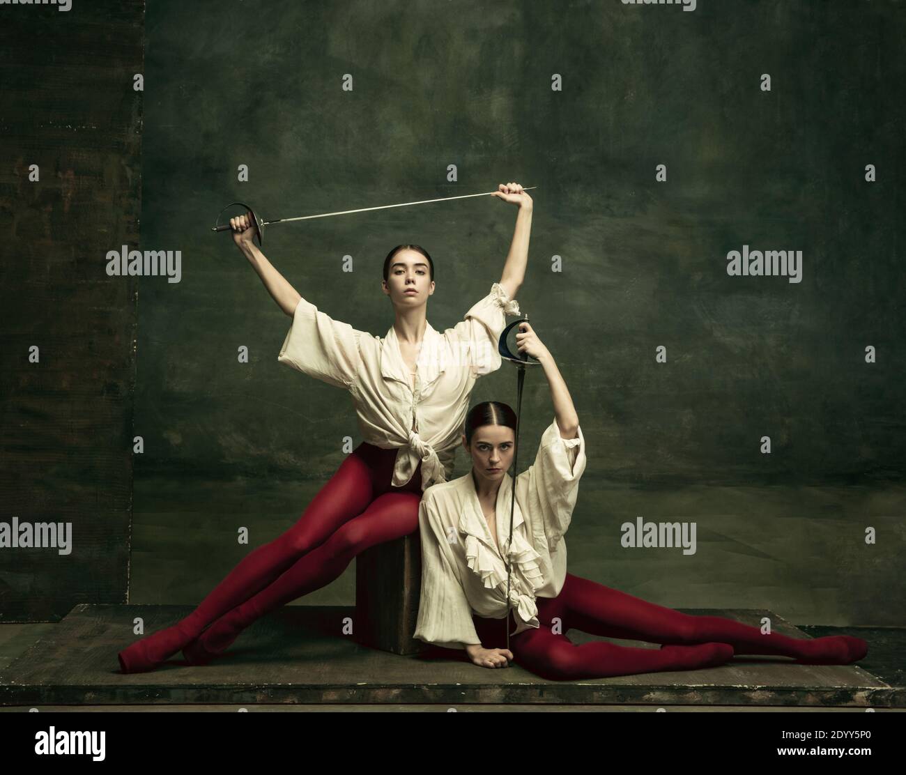 Flexibility. Two young female ballet dancers like duelists with swords ...