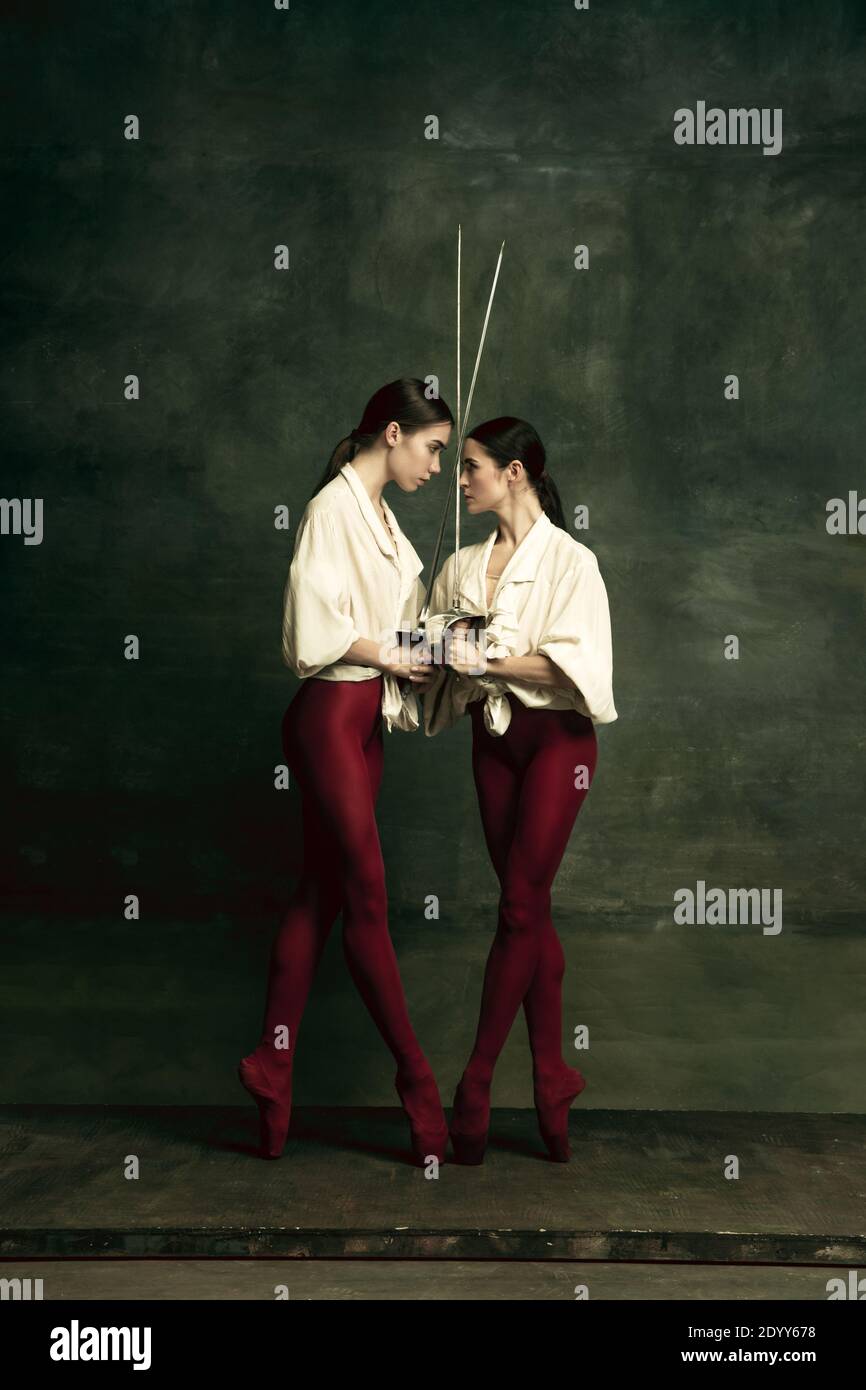 Emotions. Two young female ballet dancers like duelists with swords on ...