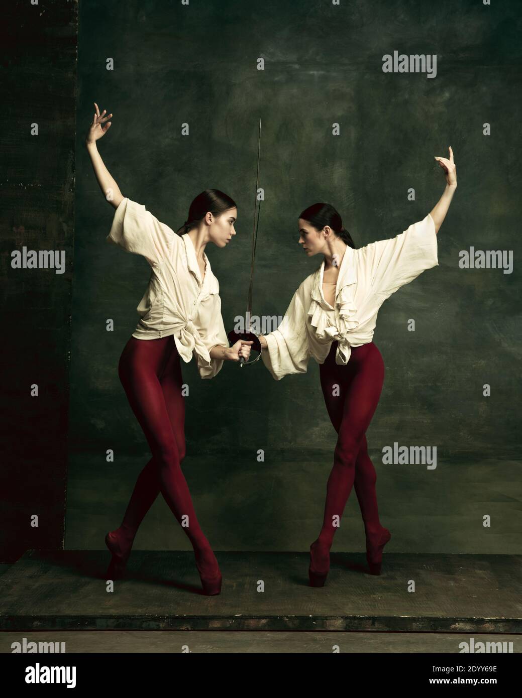 Emotions. Two young female ballet dancers like duelists with swords on ...
