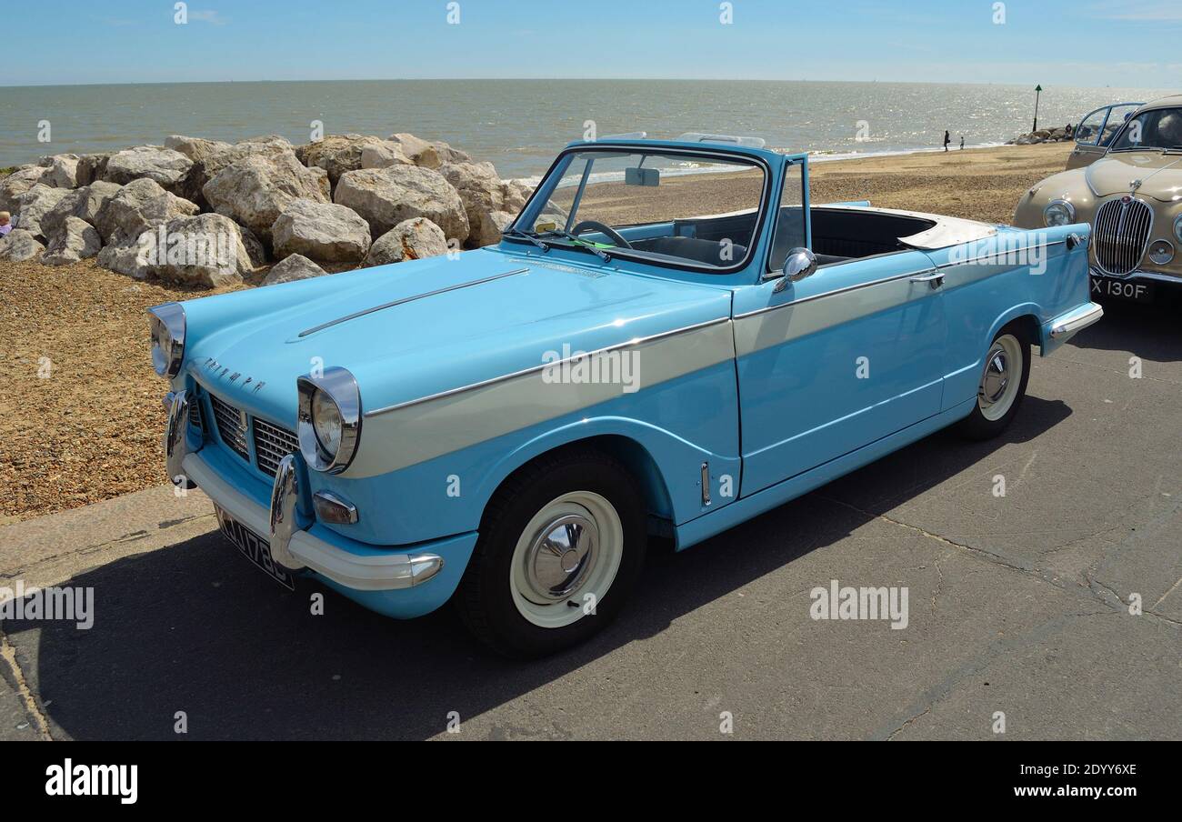 Classic light Blue Triumph Herald open top motor car parked on seafront ...