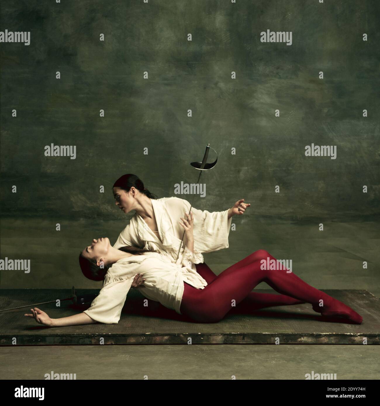 Tragic. Two young female ballet dancers like duelists with swords on ...