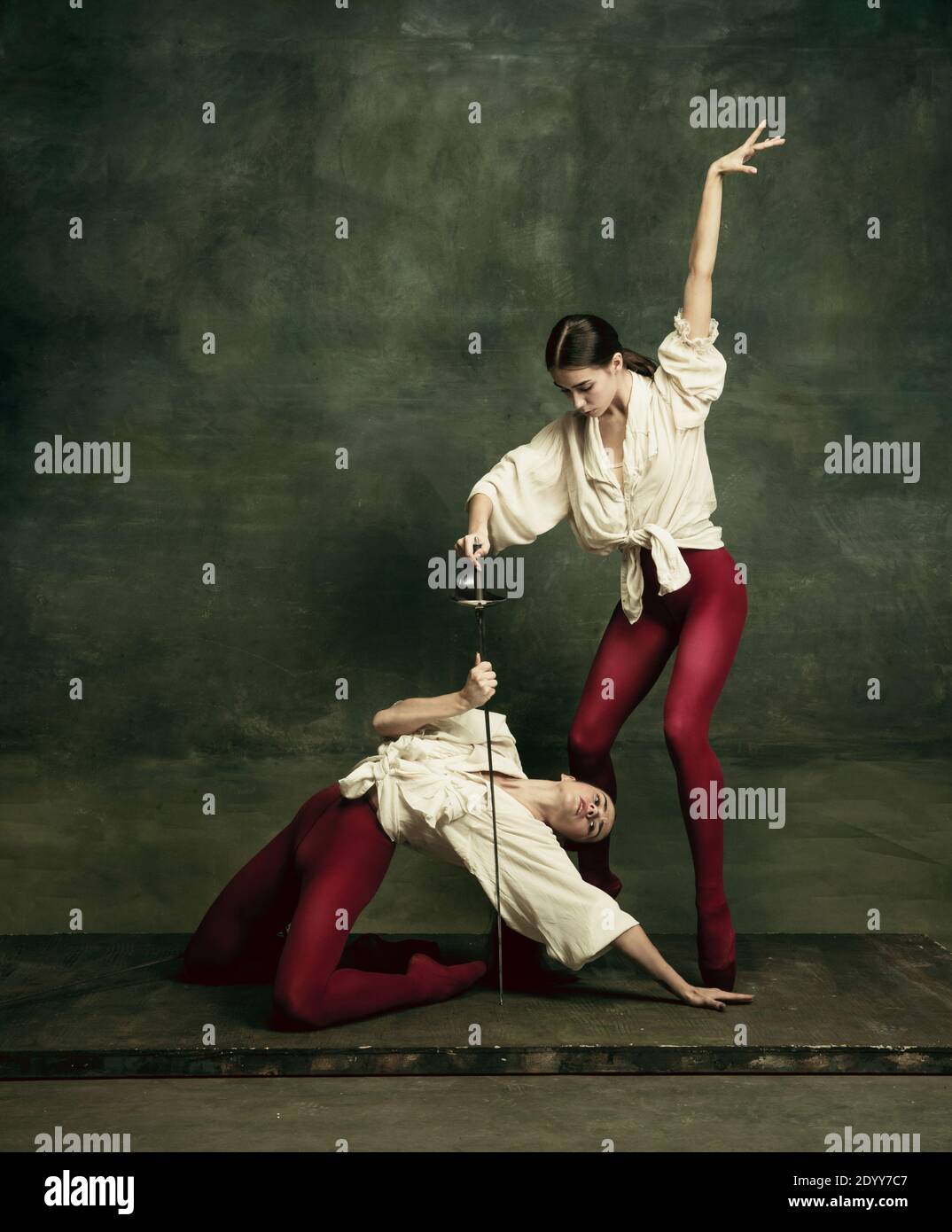 Action. Two young female ballet dancers like duelists with swords on ...