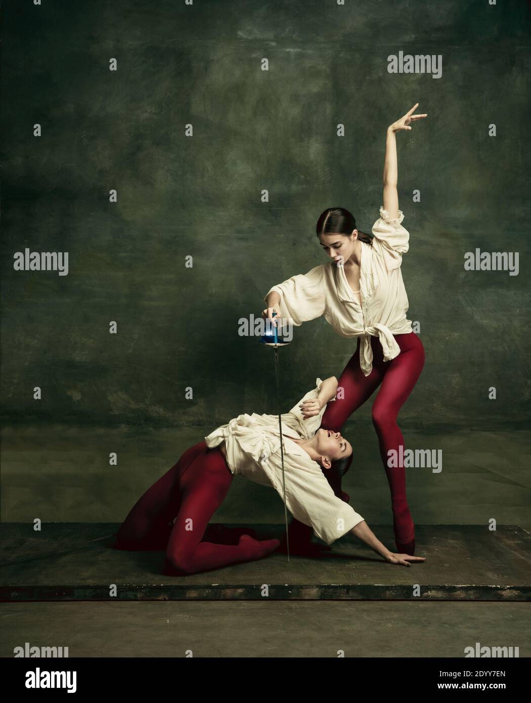 Action. Two young female ballet dancers like duelists with swords on ...