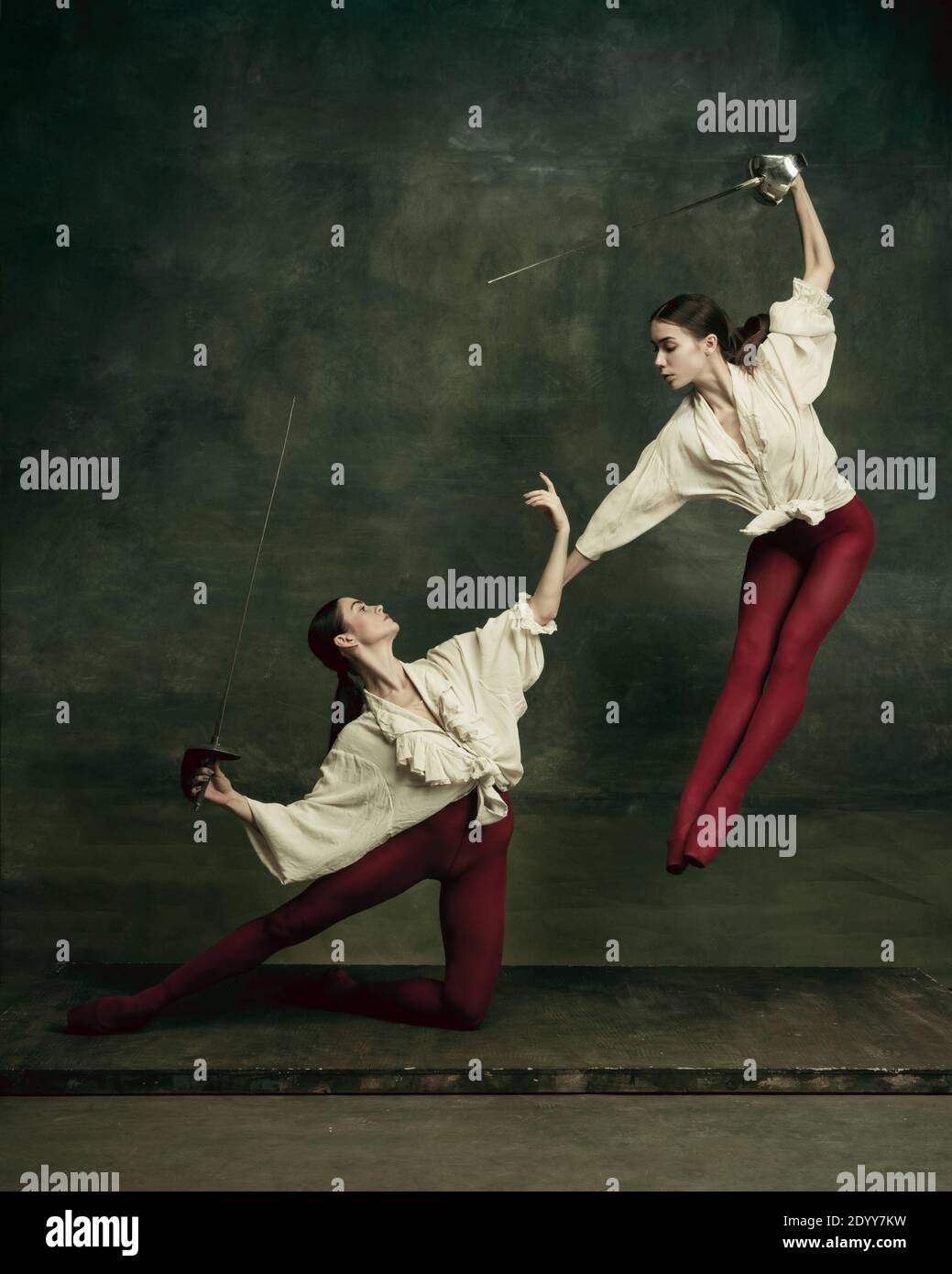 Motion. Two young female ballet dancers like duelists with swords on ...