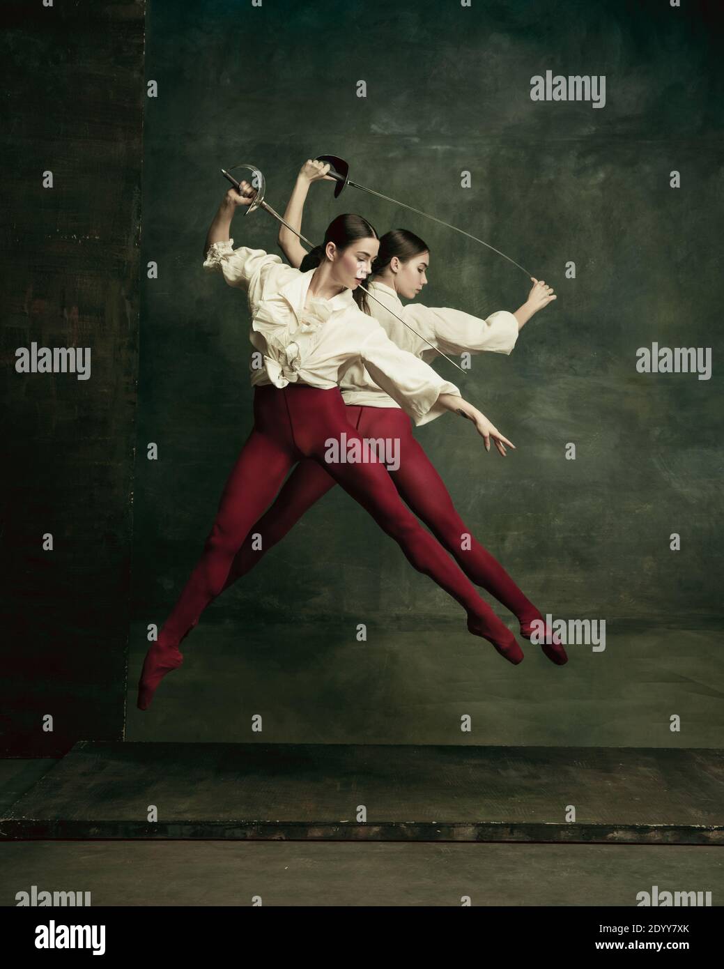 Fighting. Two young female ballet dancers like duelists with swords on ...