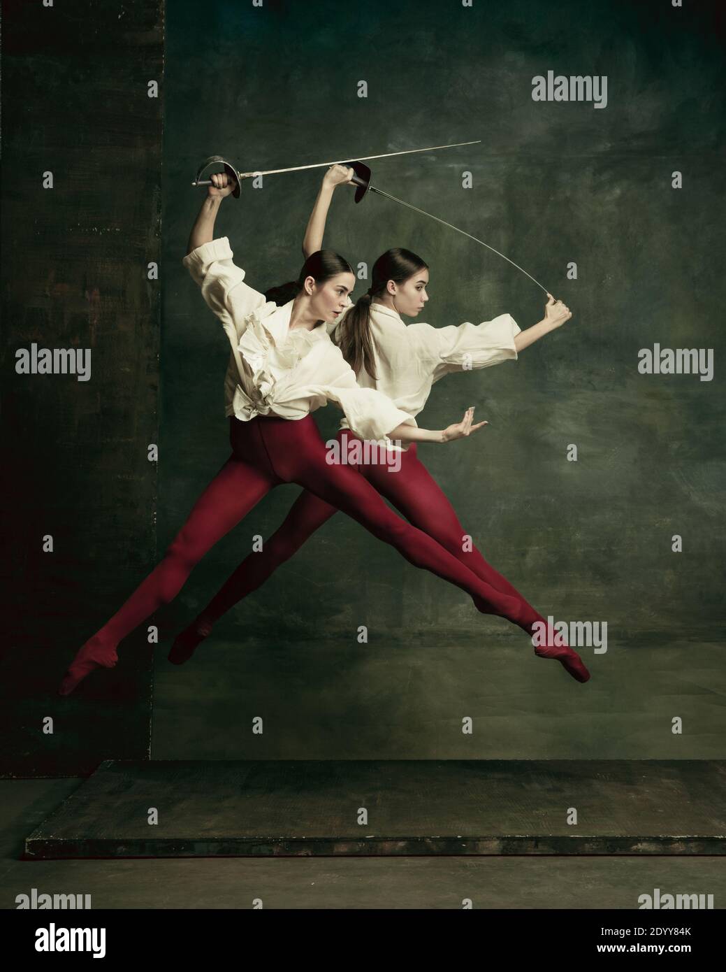 Fight. Two young female ballet dancers like duelists with swords on ...