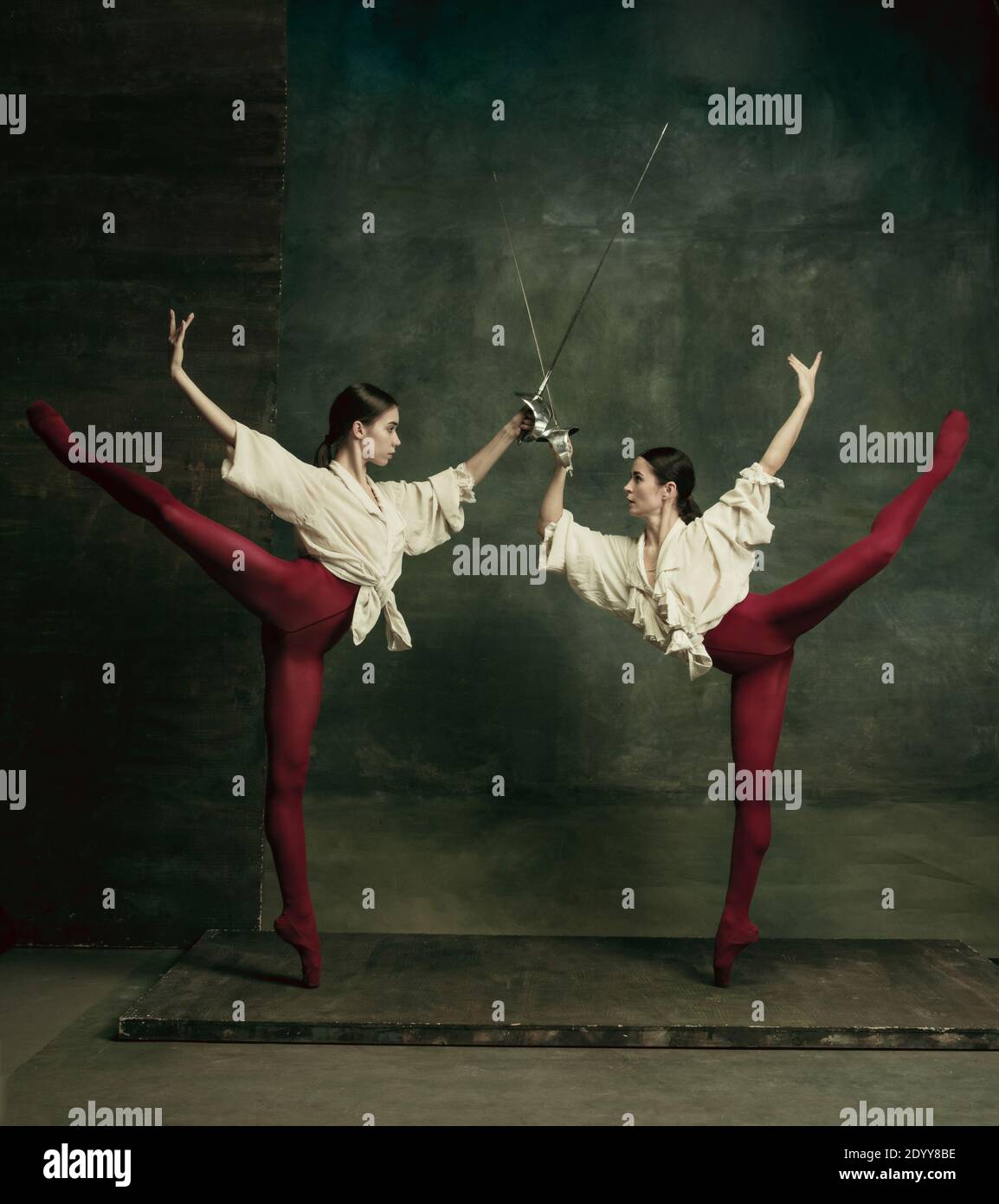 Flying. Two young female ballet dancers like duelists with swords on ...